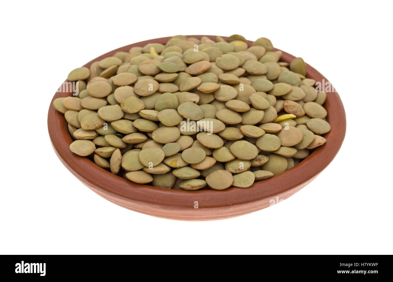 Organic green lentils in a small bowl isolated on a white background ...