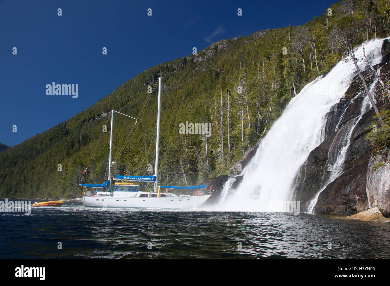 Sail boat driving up to at base of waterfall in Kynoch Inlet, British ...