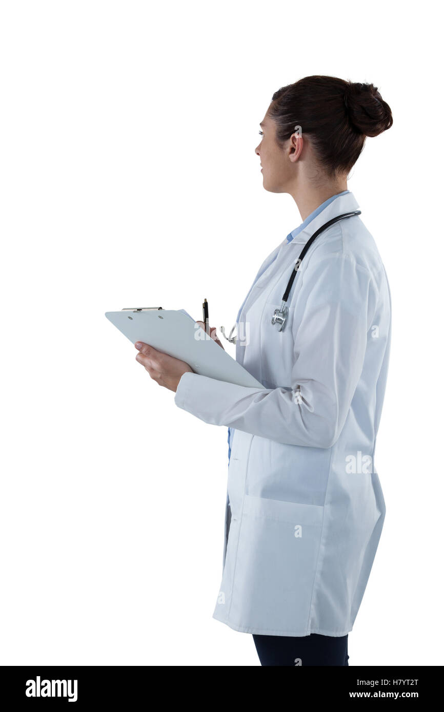 Female doctor holding clipboard and looking away Stock Photo - Alamy