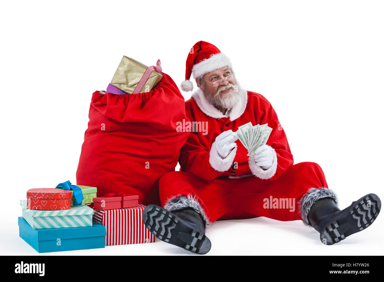 Santa claus sitting next to gift counting a currency note Stock Photo ...
