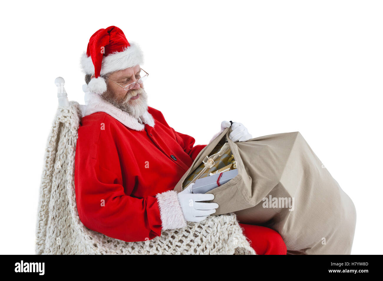 Santa claus sitting on chair and looking at gifts Stock Photo - Alamy