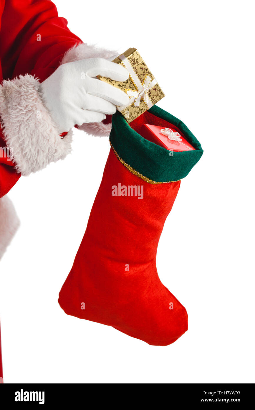 Santa claus putting presents in christmas stockings Stock Photo - Alamy