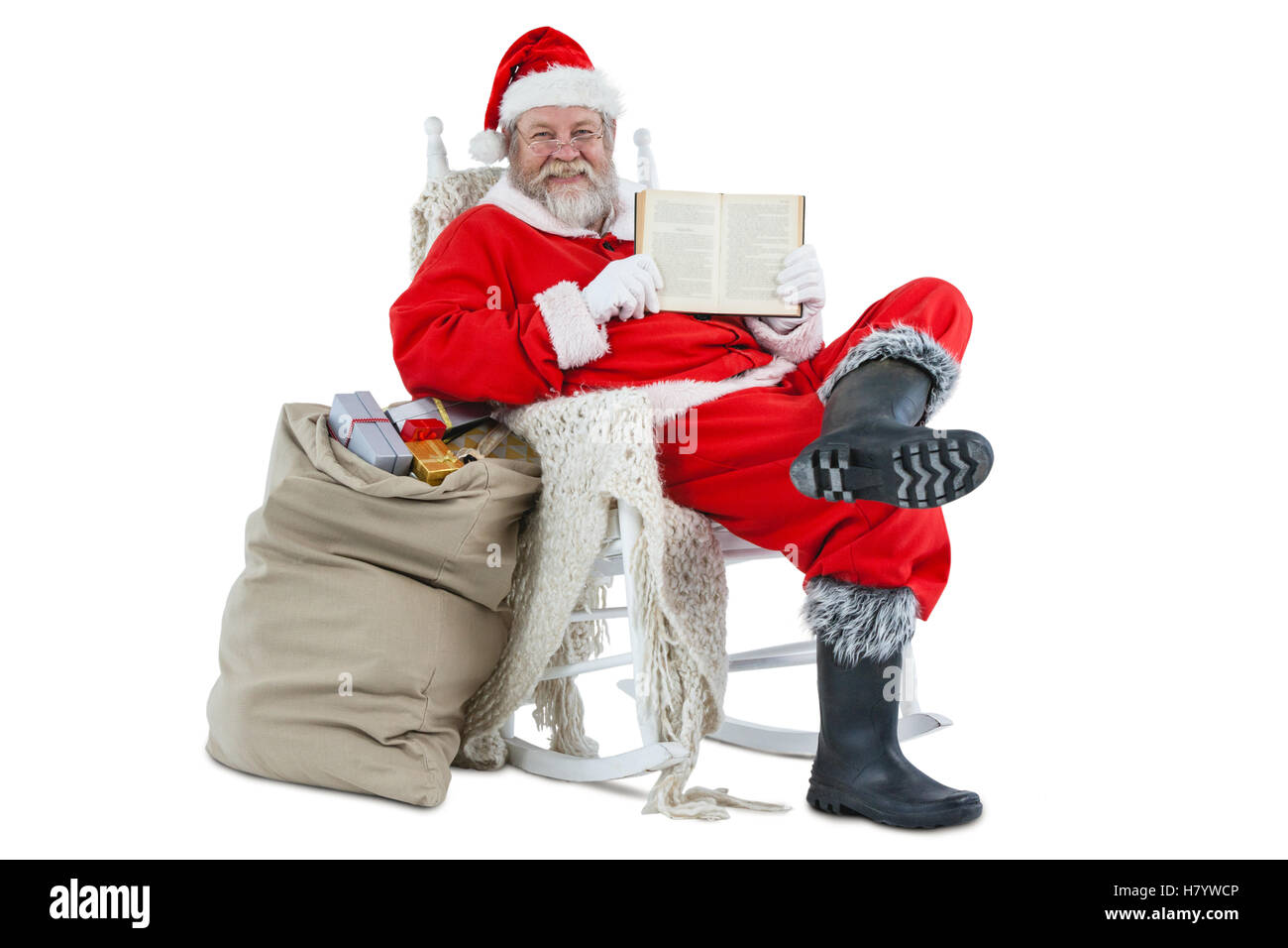 Santa claus showing bible with sack of christmas present beside him ...