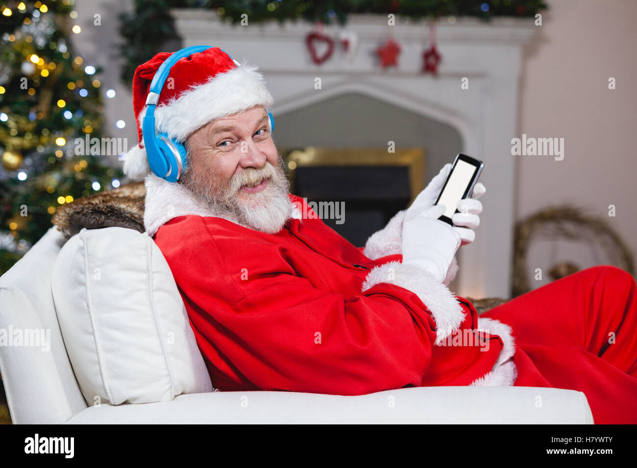 Santa claus using mobile phone at home Stock Photo - Alamy