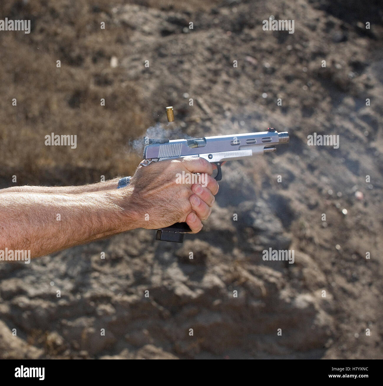 Semi automatic handgun loading another round while brass flies Stock ...