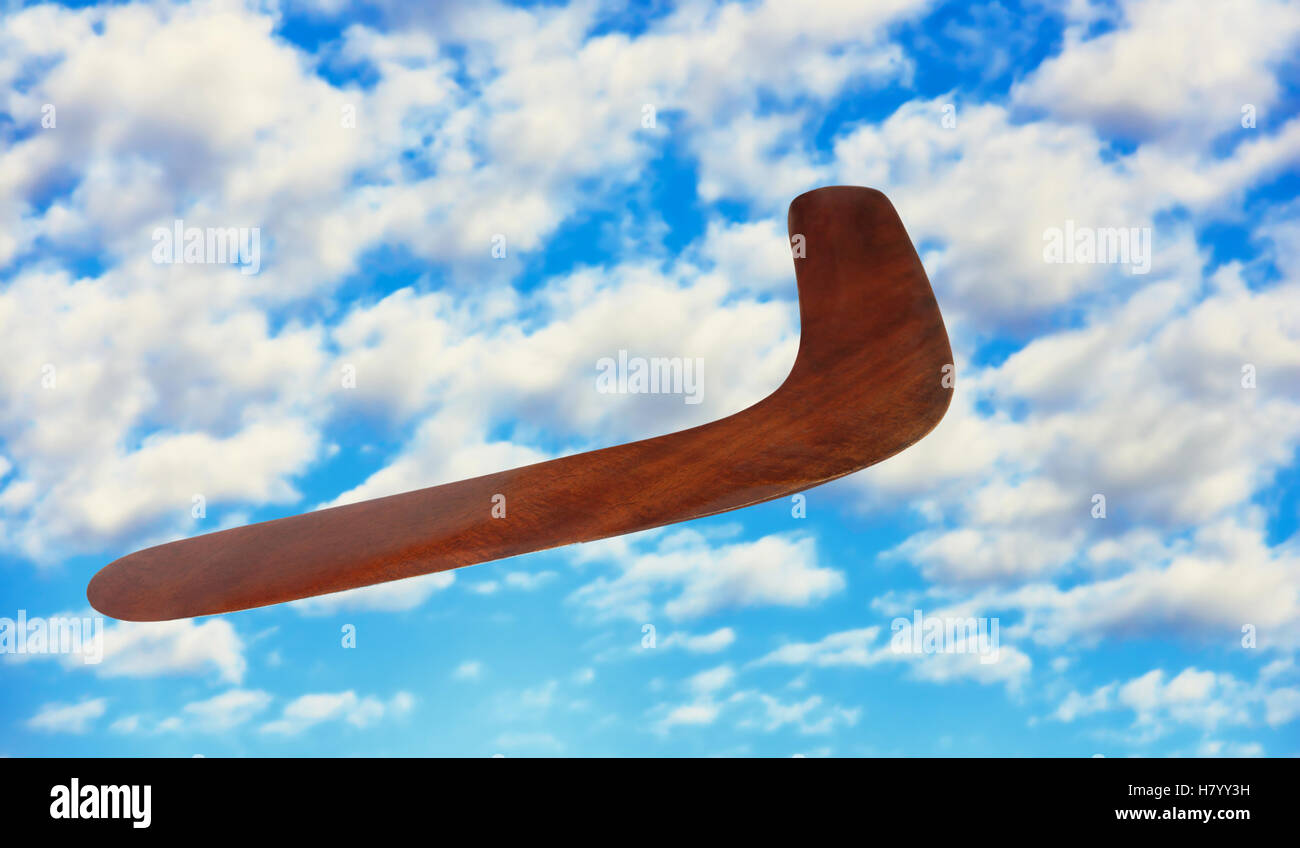 Australian boomerang in flight against of pure white clouds and blue ...
