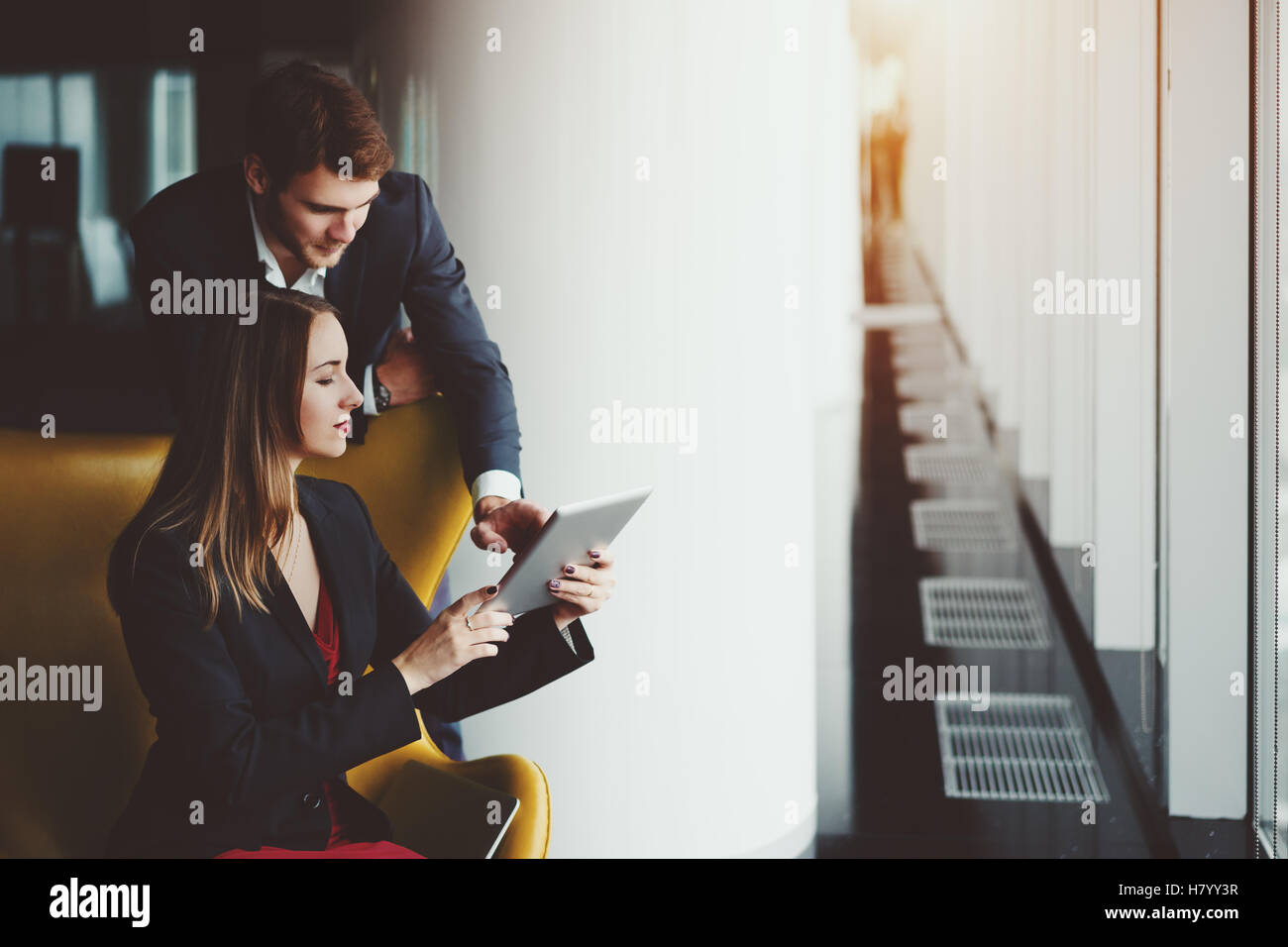 Female secretary in red dress and jacket sitting next to window on ...