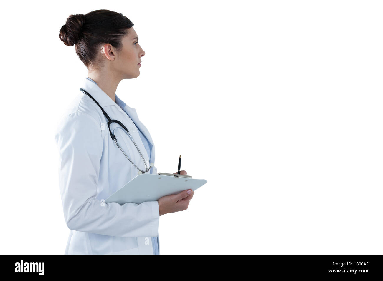 Female doctor holding clipboard and looking away Stock Photo - Alamy