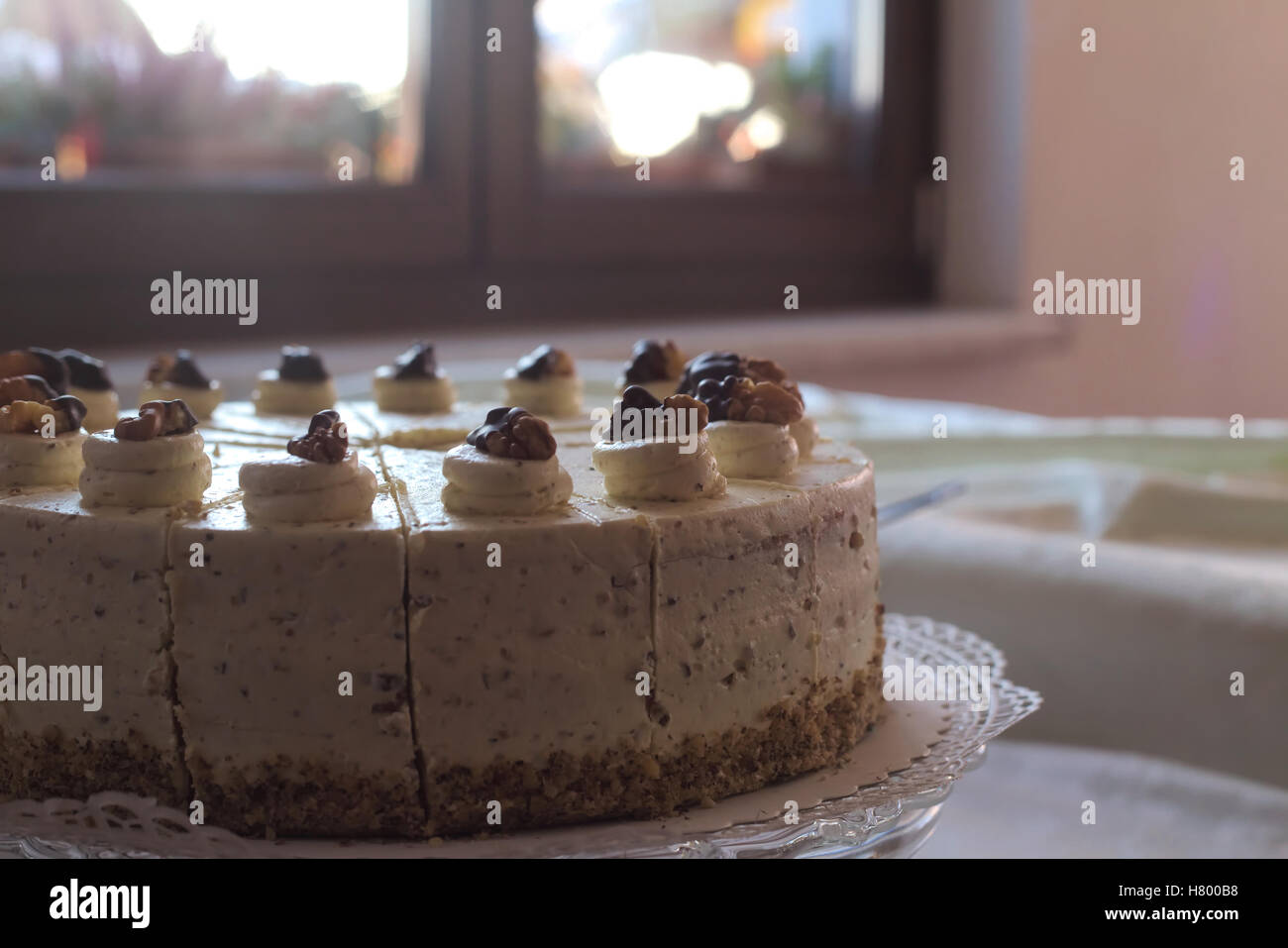 Walnut stracciatella cake in front of window Stock Photo - Alamy
