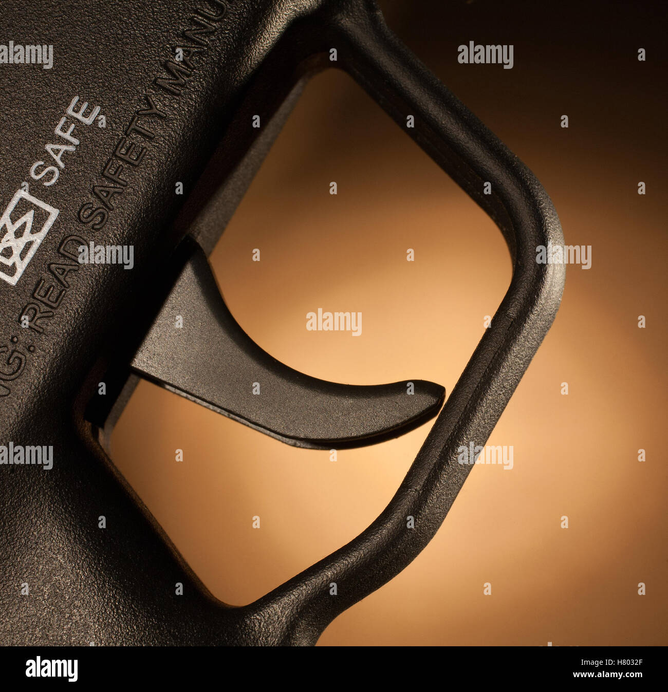 Assault rifle trigger that has a tan background behind Stock Photo - Alamy
