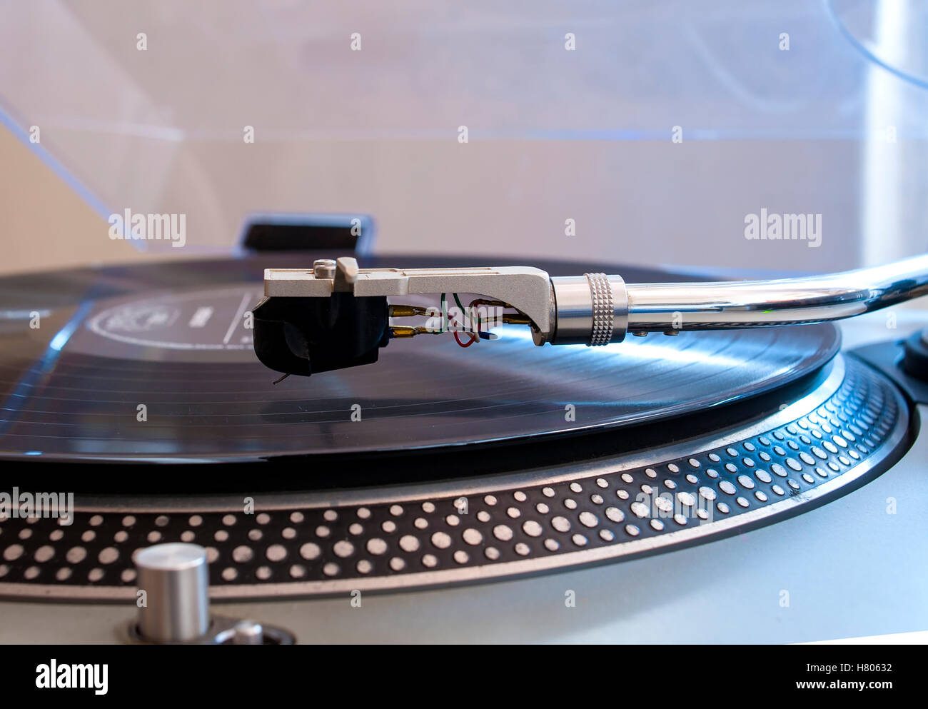 Close up of a turntable needle head playing music from an lp. (shallow ...