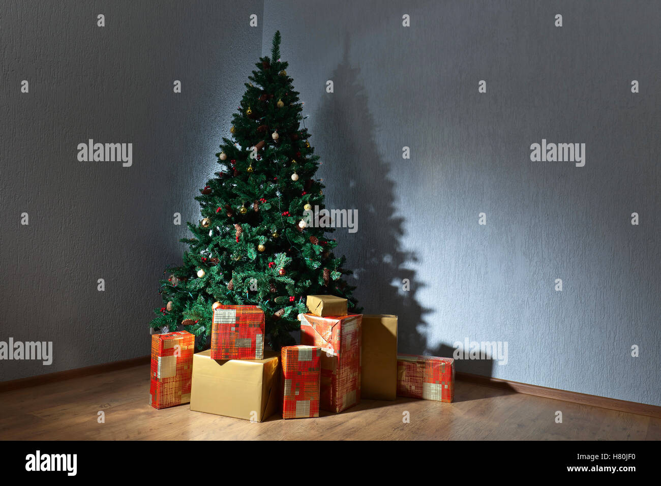 Christmas tree with gifts in an empty room Stock Photo - Alamy