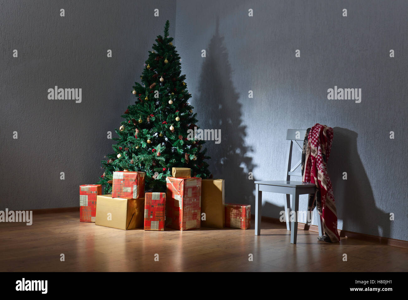 Christmas tree with gifts in an empty room Stock Photo - Alamy