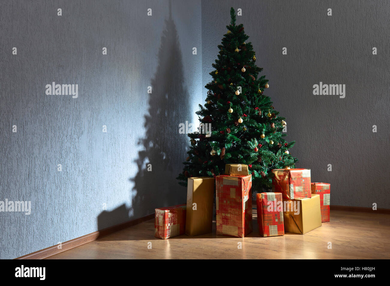 Christmas tree with gifts in an empty room Stock Photo - Alamy