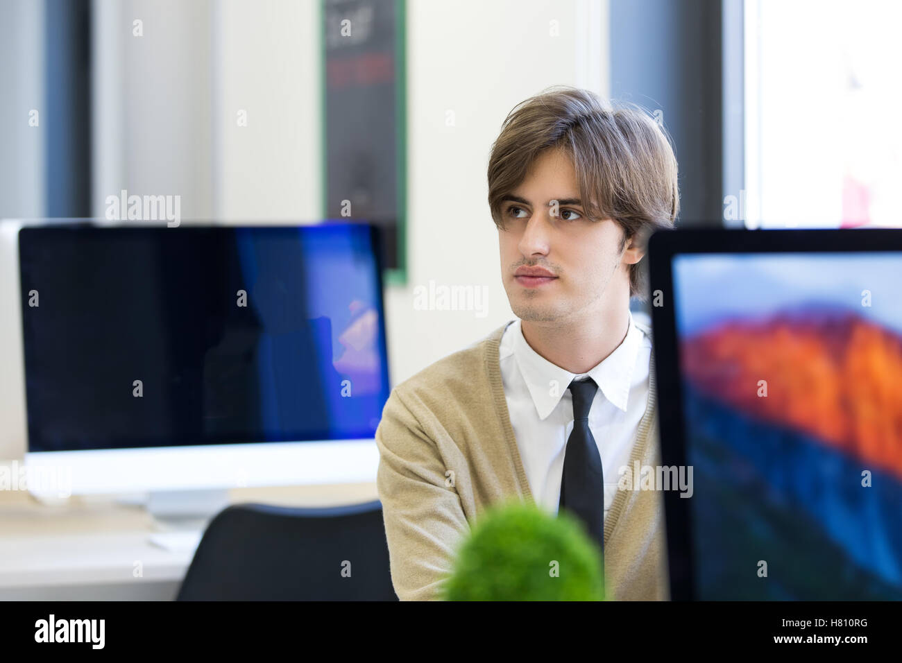 Cheerful guy sitting in front of desktop computer Stock Photo - Alamy