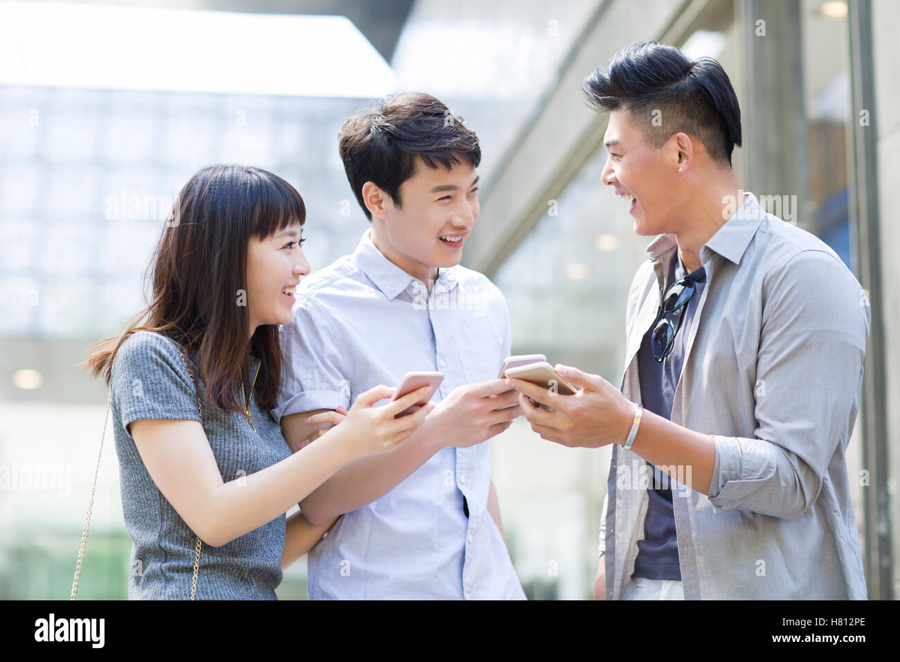 Young Chinese friends holding smart phones Stock Photo - Alamy