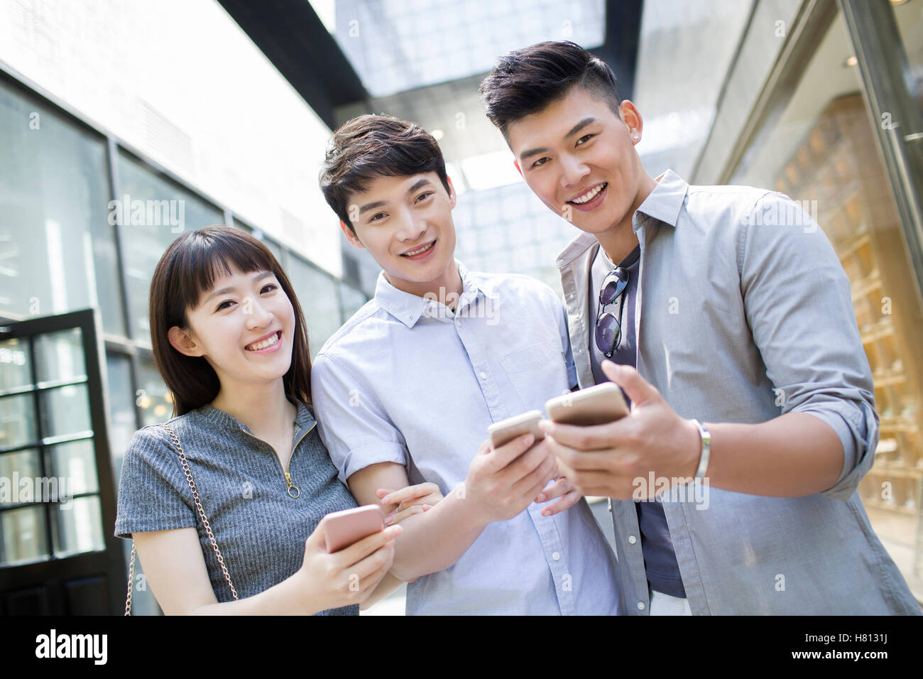 Young Chinese friends holding smart phones Stock Photo - Alamy
