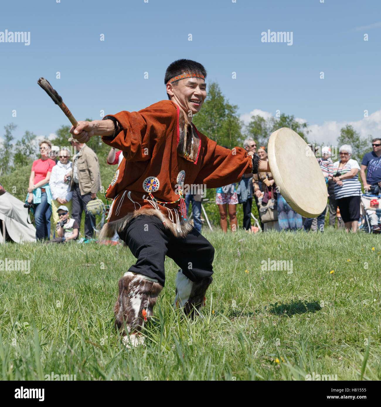 Man in clothes indigenous people of Kamchatka dancing with tambourine ...