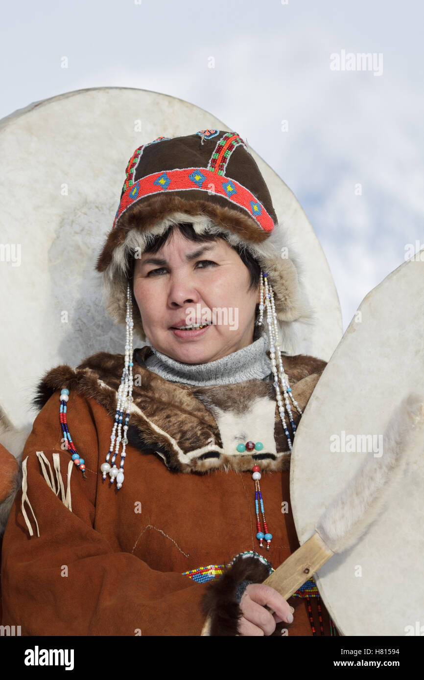 Portrait of woman dressed in Koryak national dress with tambourine ...
