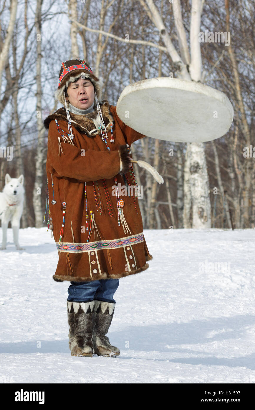 Woman in Koryak national dress dancing, beats the tambourine and ...