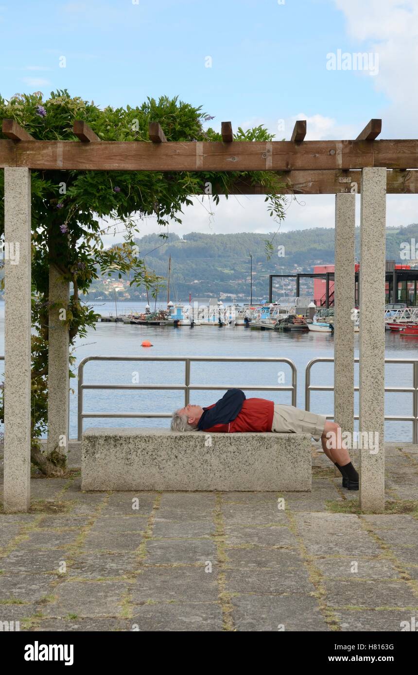 Man resting on a bench in the village of Combarro in the province of ...