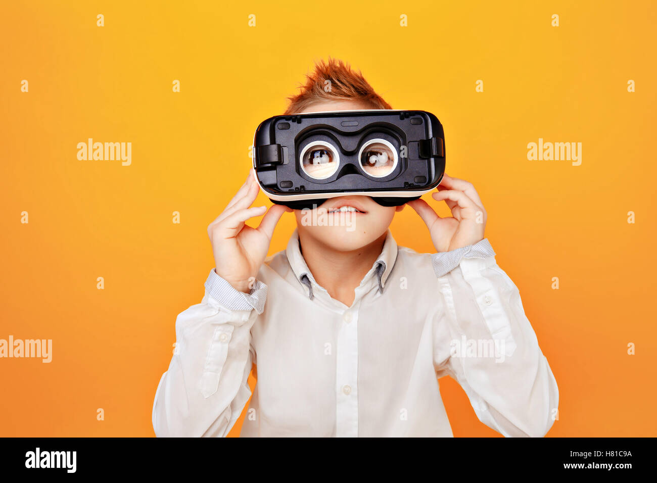 Kid looking at camera through VR glasses Stock Photo - Alamy