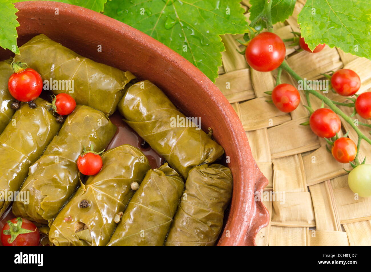 Sarma rolls in a traditional plate with cherry tomato Stock Photo - Alamy