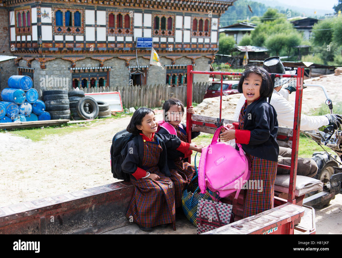 Young school girls get a ride on a tractor-drawn trailer in rural ...