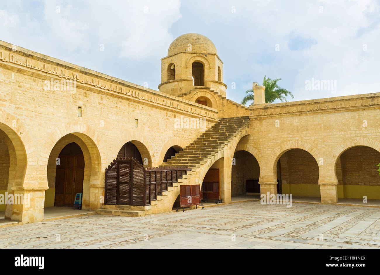 The stone courtyard of the Grand Mosque with the long arcades on each ...