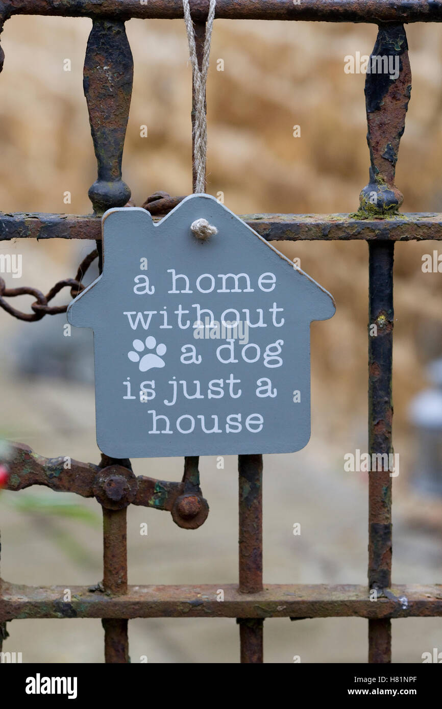 sign on a metal rusted gate saying " A Home without a dog, is Just a ...