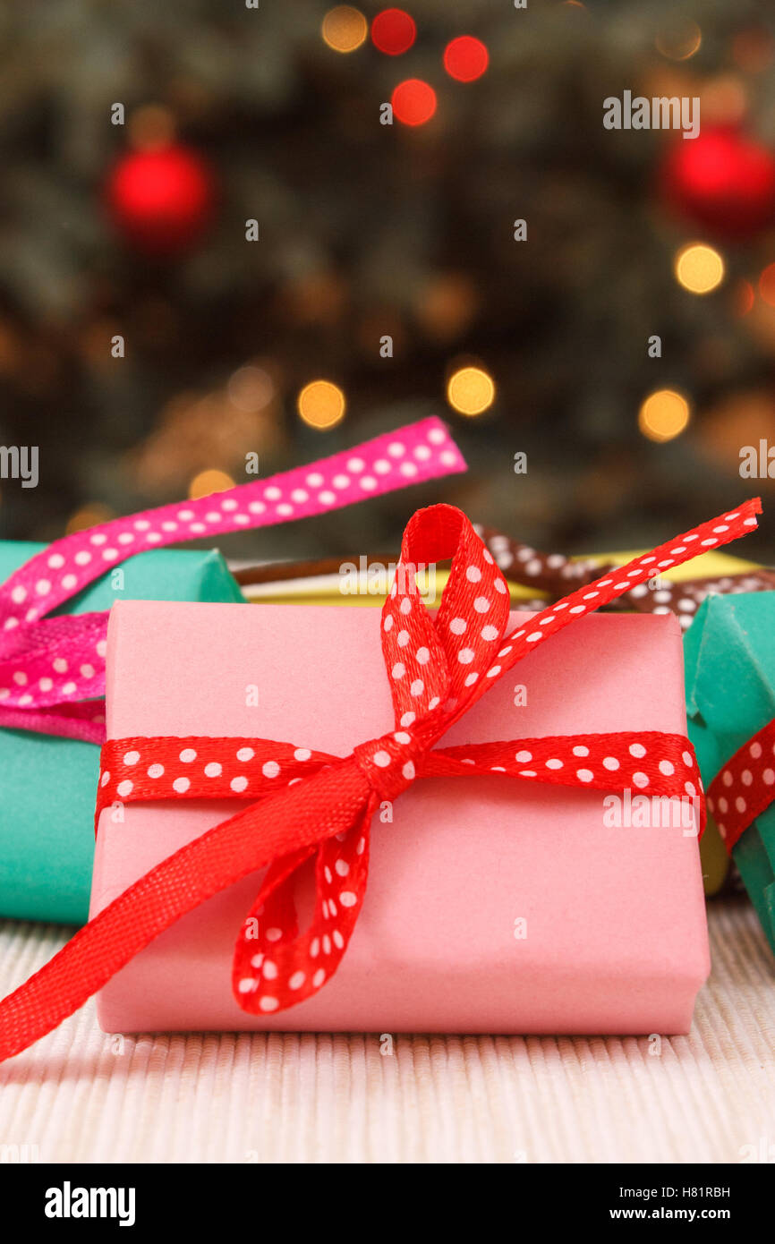 Colorful wrapped gifts with ribbons for xmas and christmas tree with ...