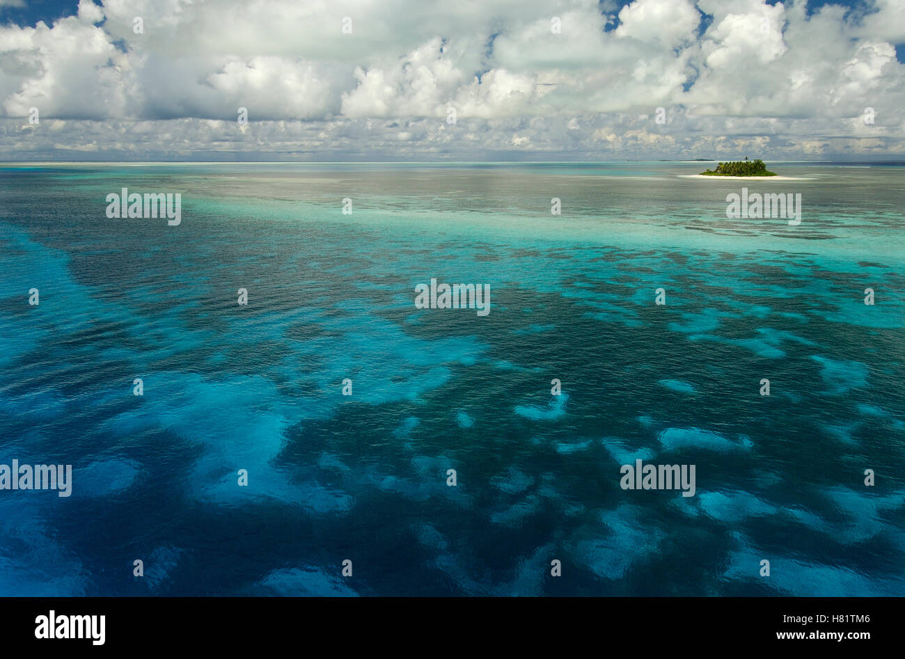 Clouds above sea and island with barrier reef, Bijoutier Island ...