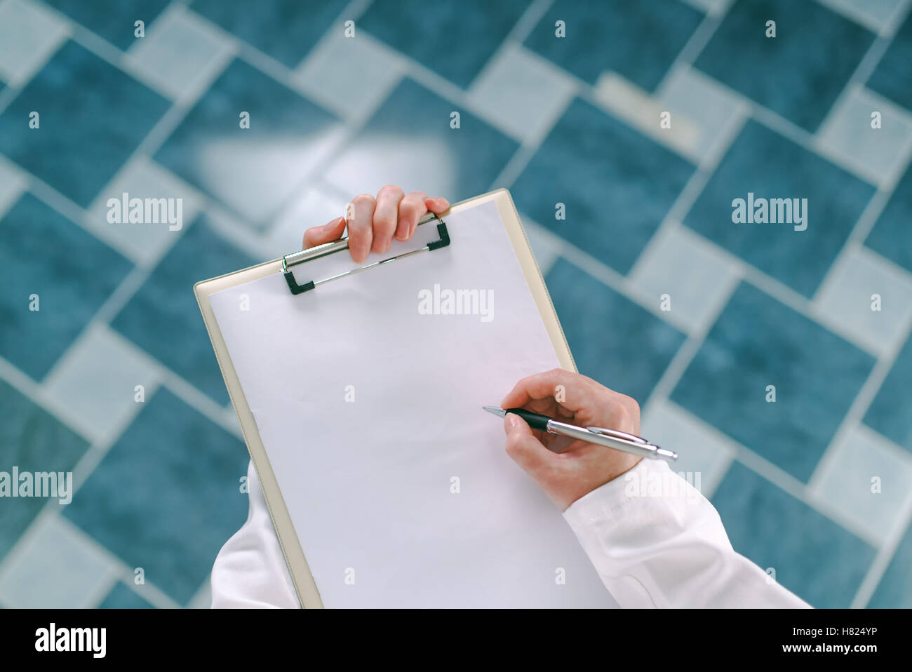Female doctor in white uniform writing on clipboard paper medicine ...