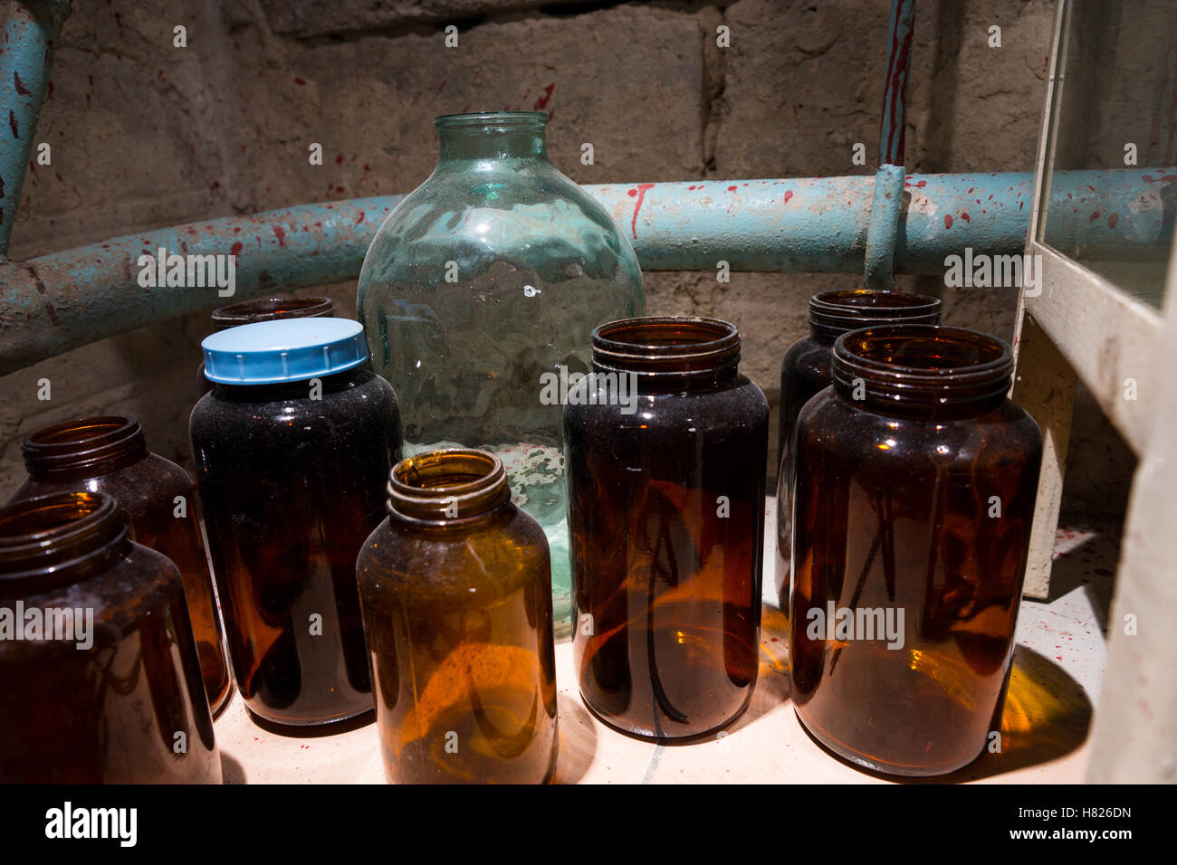 Glass jars and bottles with blood spattered wall in stained laboratory ...