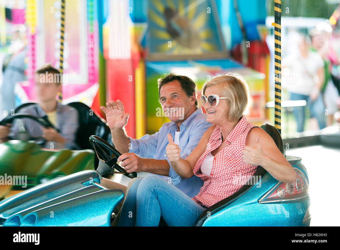 Senior couple in the bumper car at the fun fair Stock Photo - Alamy