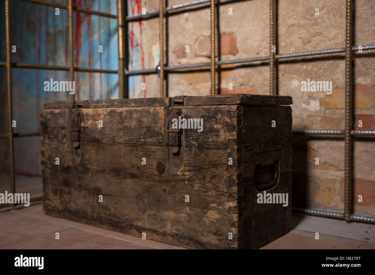 Old chest in the iron cage behind blood splattered wall for concept ...
