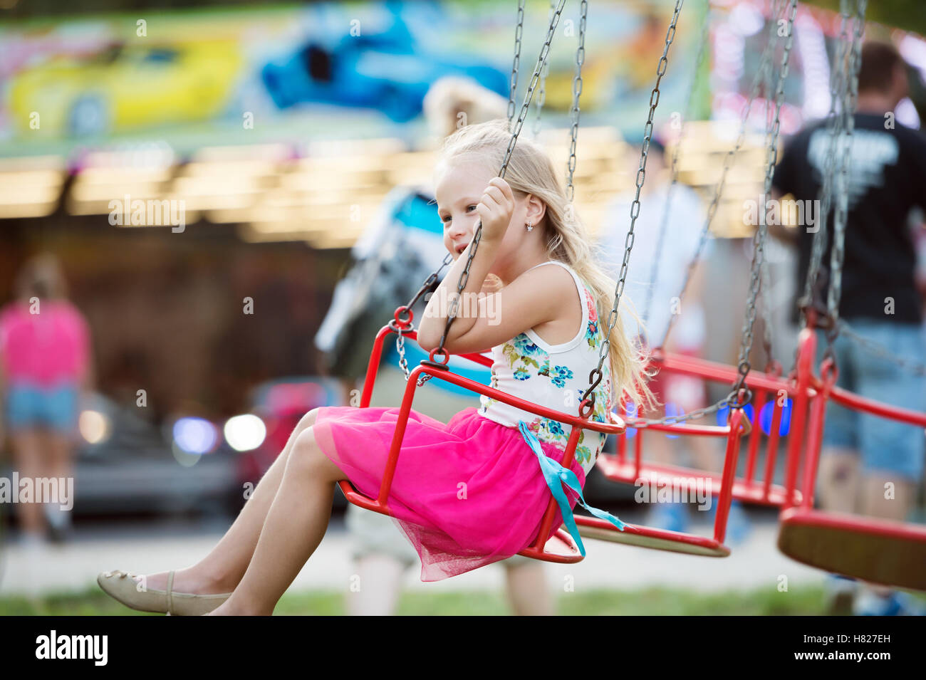 Cute little girl at fun fair, chain swing ride Stock Photo - Alamy
