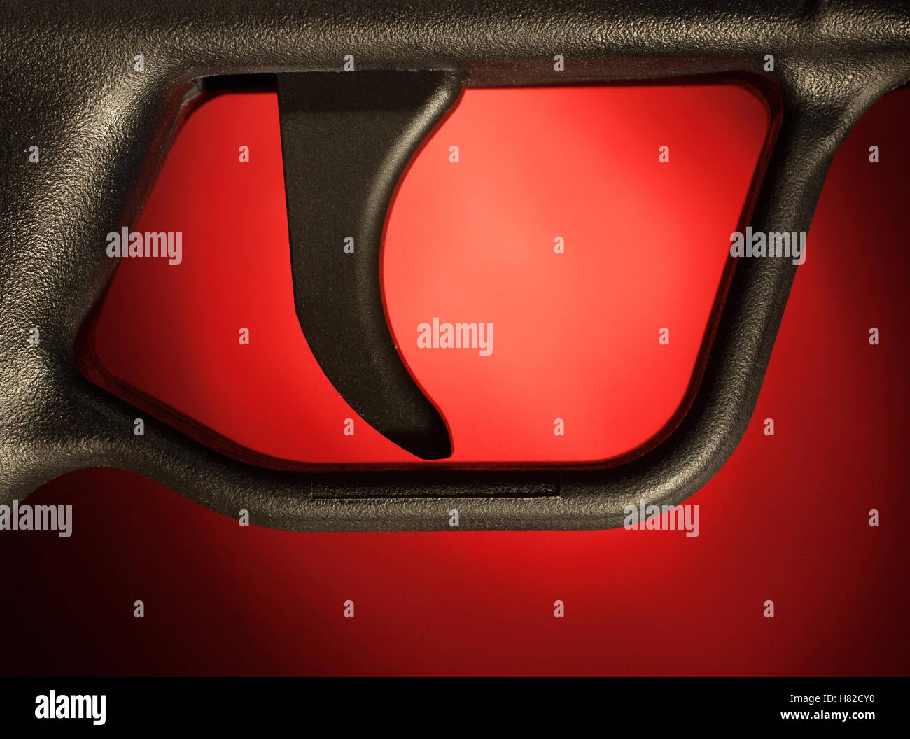 Metal trigger on an assault rifle with a red background Stock Photo - Alamy