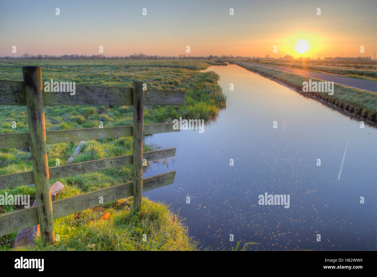 Meadow and river channel with fence at sunset, Gouda, Netherlands Stock ...
