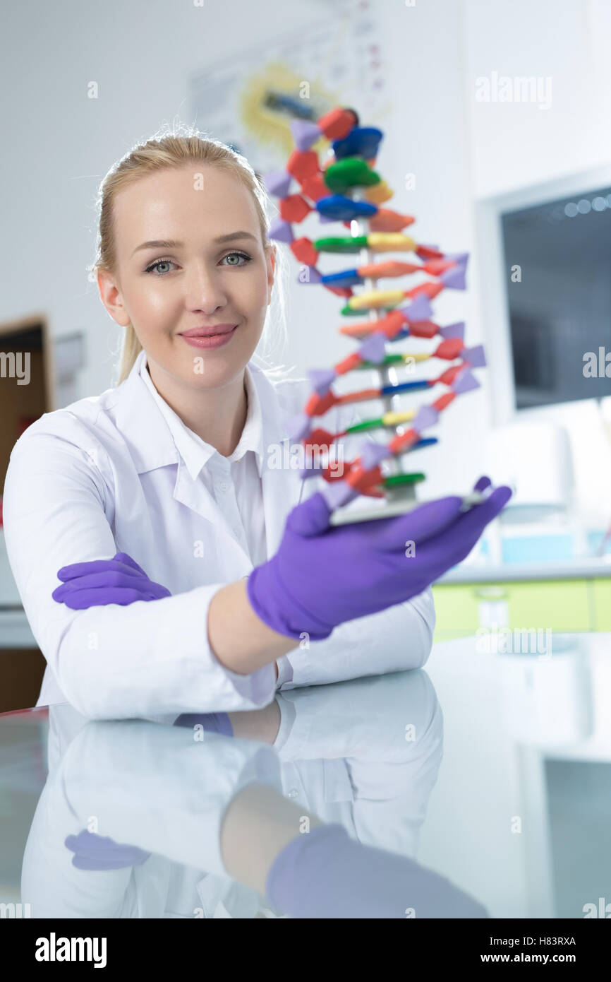 Woman scientist holding DNA molecule Stock Photo - Alamy
