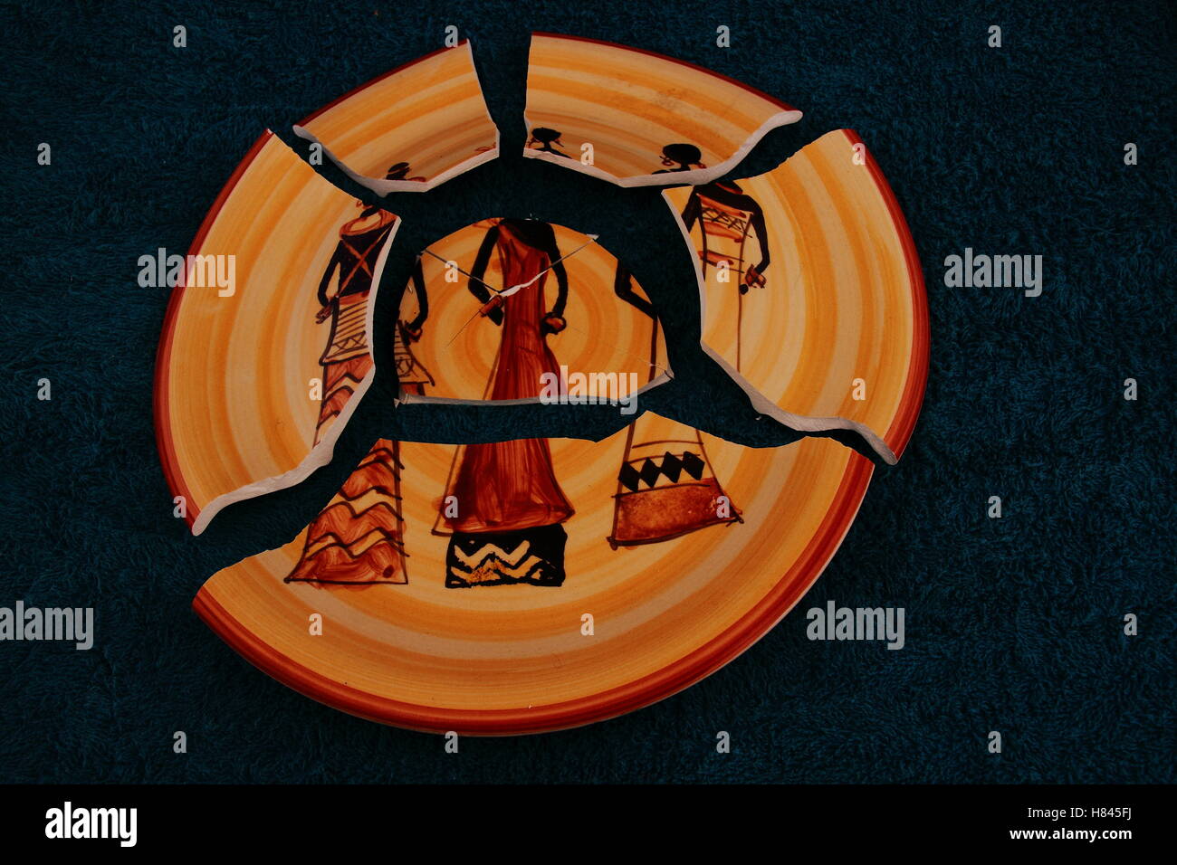 A broken ceramic dinner plate isolated on a blue background image with ...