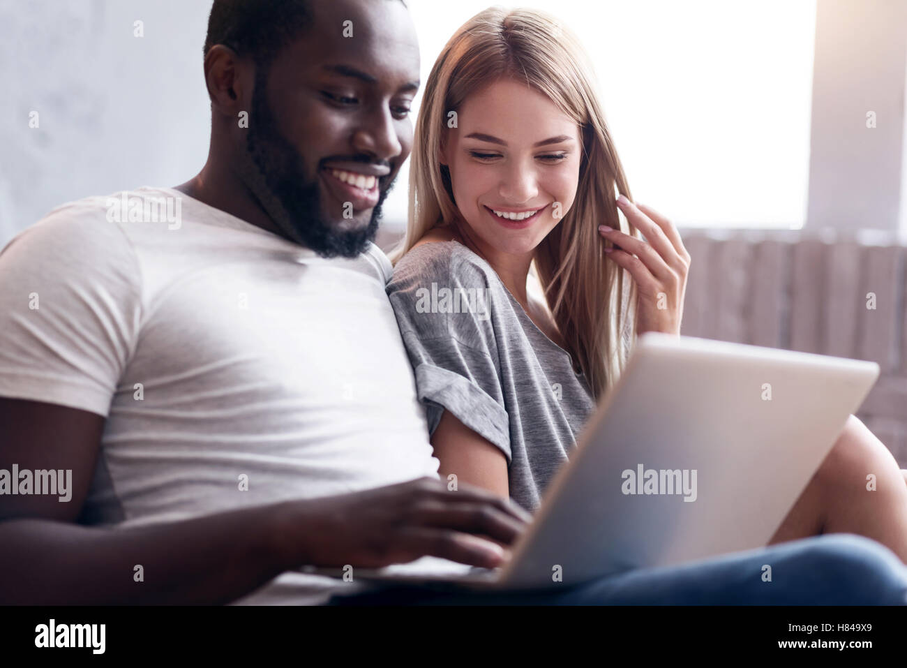 Laughing couple using laptop together Stock Photo - Alamy