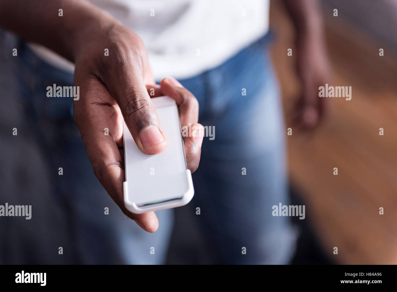 Close up of a TV remote held by African man Stock Photo - Alamy
