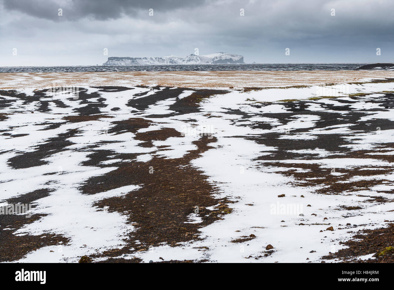 Sand spit with snow, Vik, Iceland Stock Photo - Alamy