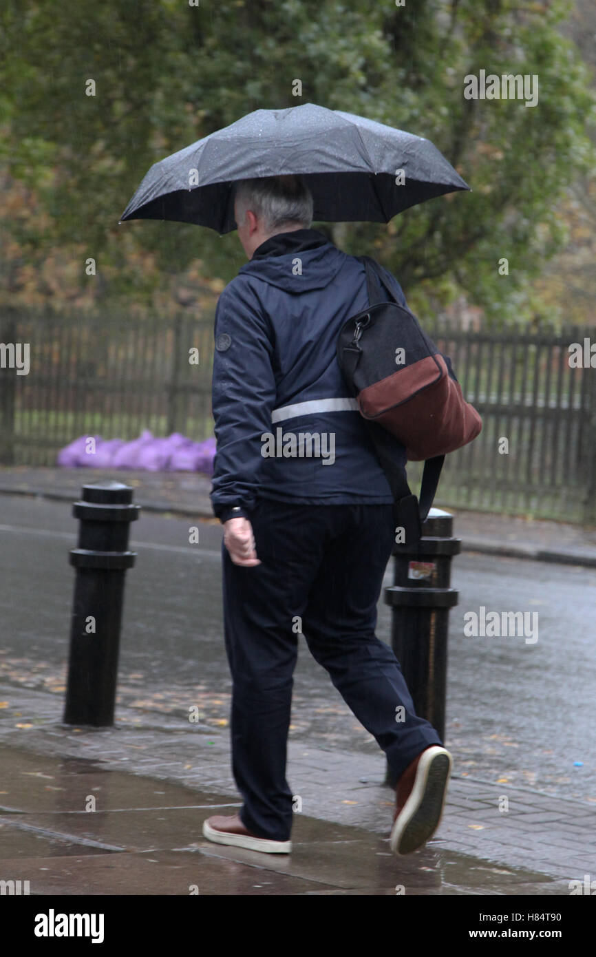 Shoppers sheltering under umbrellas hi-res stock photography and images ...