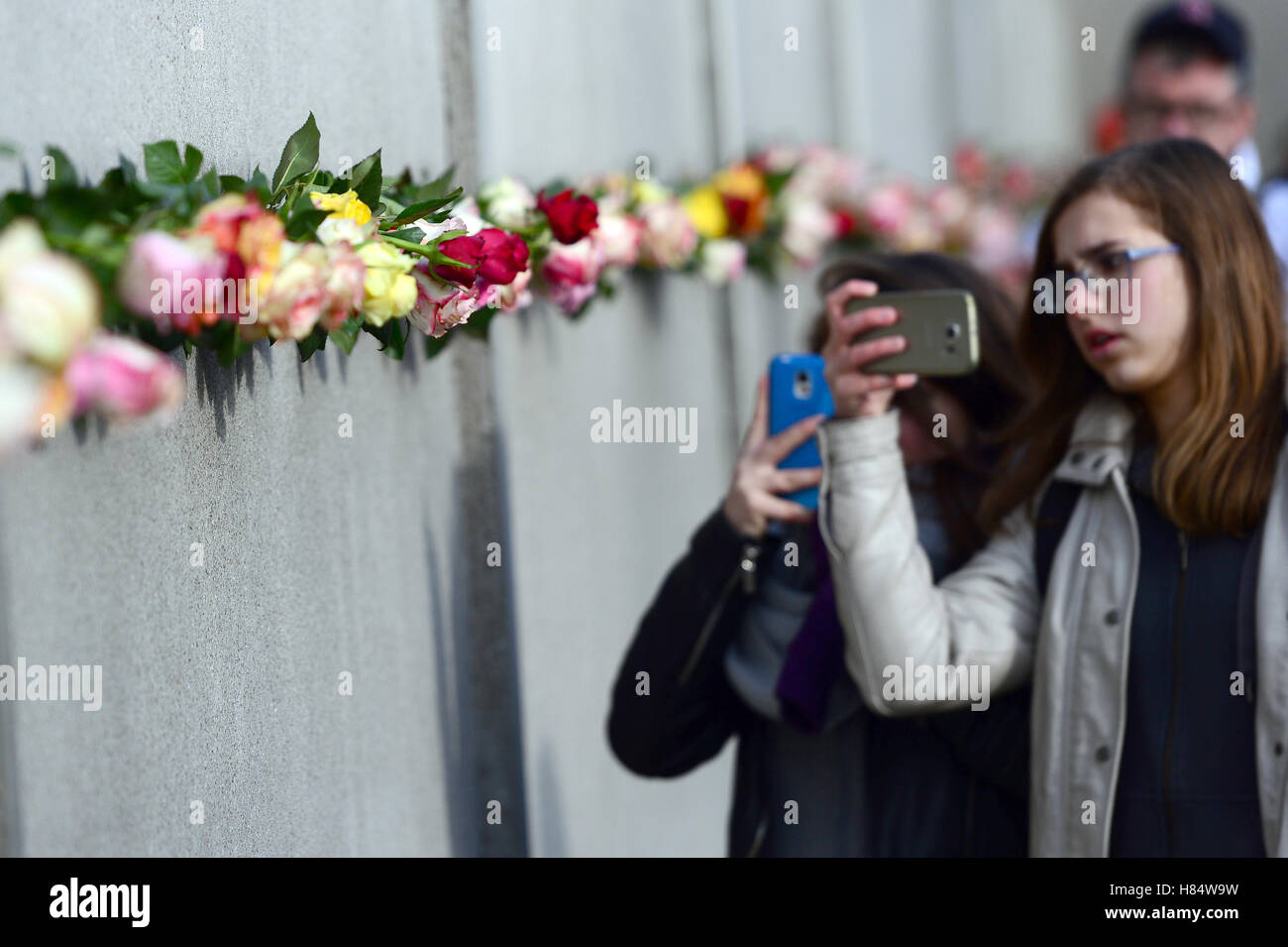Berlin, Germany. 09th Nov, 2016. Two students photograph roses sticking ...