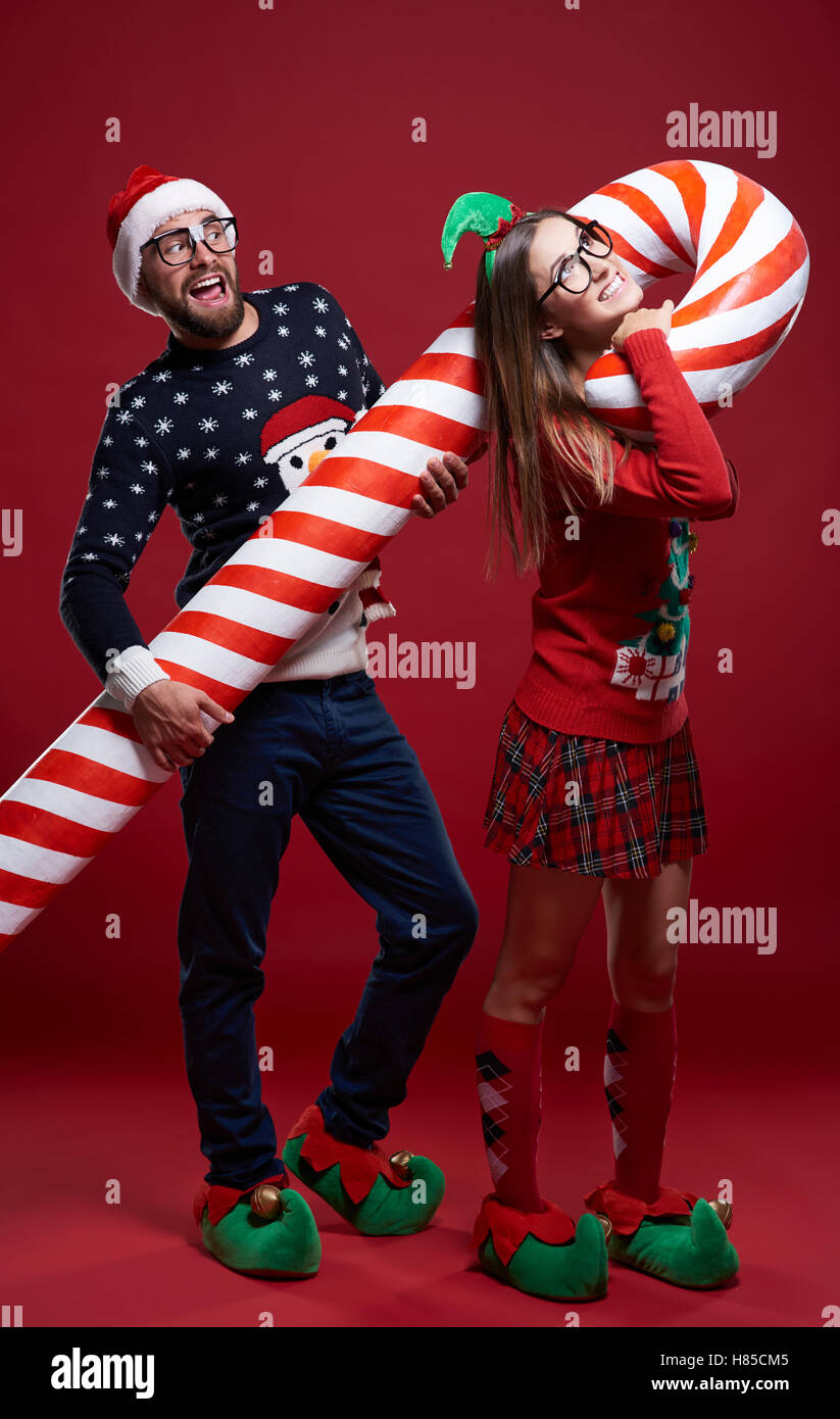 Couple carrying heavy candy cane Stock Photo - Alamy