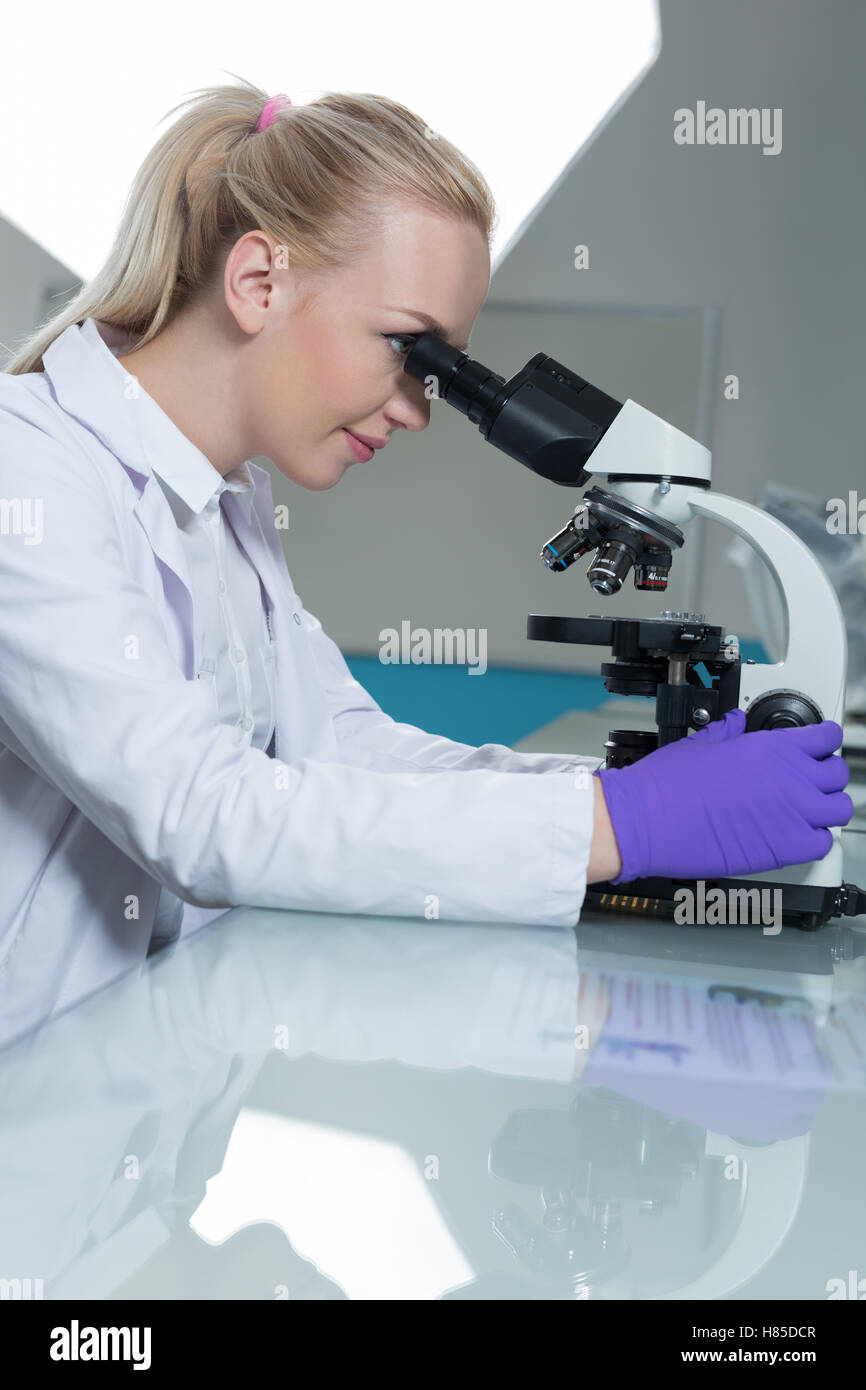 Female researcher using her microscope in a laboratory Stock Photo - Alamy