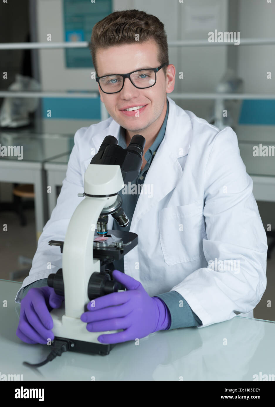 Scientist looking through a microscope in a laboratory Stock Photo - Alamy