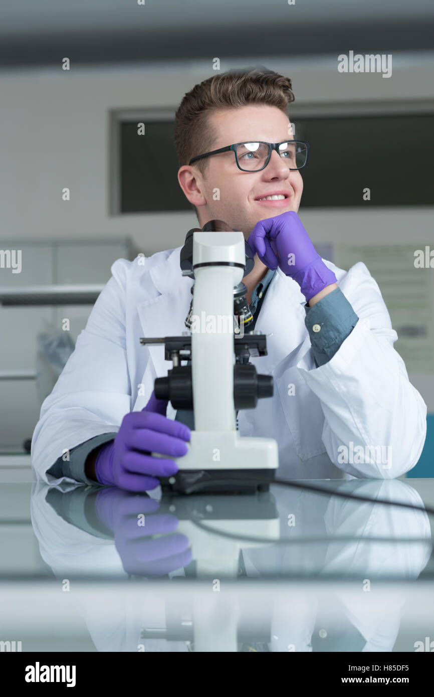 Scientist looking through a microscope in a laboratory Stock Photo - Alamy